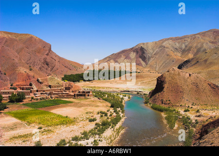 Hari Rud river through fertile valley at base of red rock mountains ...
