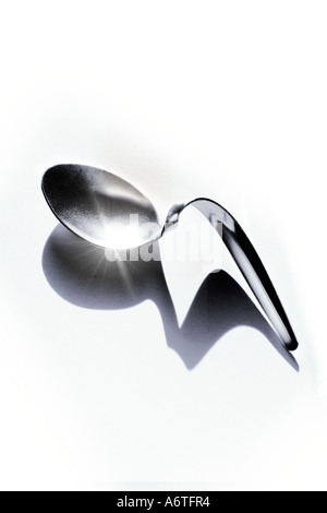A bent shiny metal spoon Stock Photo - Alamy
