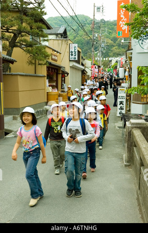 Young Japanese school children walking in a line holding hands in Ueno ...