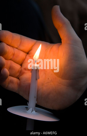 A hand shielding a candle during a candlelight vigil Stock Photo - Alamy