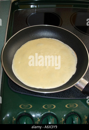 A close-up of man cooking pancakes in many of pans during an outdoor ...