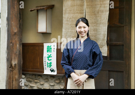 Young woman standing in restaurant holding a brown paper bag with her ...