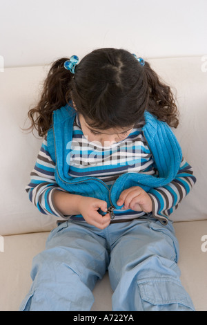 Little girl is trying to close the zipper of her jacket Stock Photo - Alamy