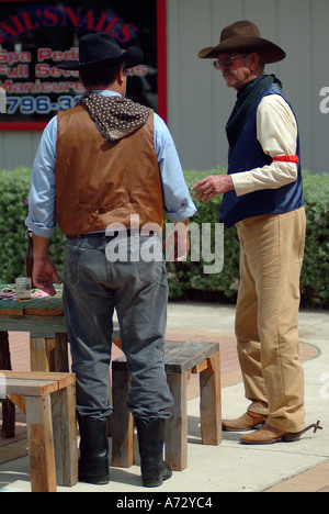 Two cowboys actors playing card sitting around a wood table Stock Photo ...