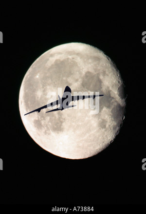 Aeroplane flying across a full moon Stock Photo - Alamy