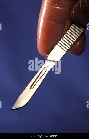 Gloved hand holding a scalpel Stock Photo - Alamy