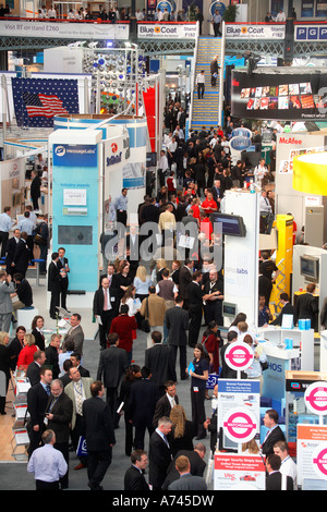 Crowd of people at a trade show booth with a banner and the text Trade ...