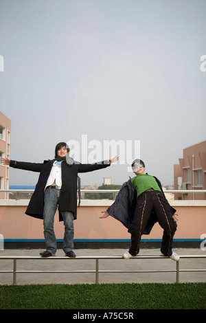 Man balancing on metal railing Stock Photo - Alamy