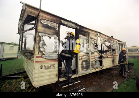 A Firefighter in action at a caravan fire, Britain UK Stock Photo - Alamy