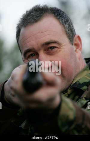 Man pointing shotgun at the camera Stock Photo - Alamy