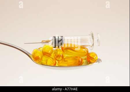 Small syringe on a spoon with oil capsules Stock Photo - Alamy
