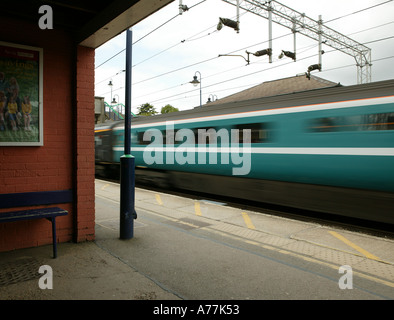 red train speeding past empty station Stock Photo - Alamy