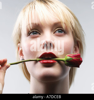 seductive woman holding red rose with teeth isolated on black Stock ...