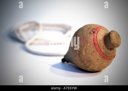 Old, wooden spinning top toy made of wood with string on white ...