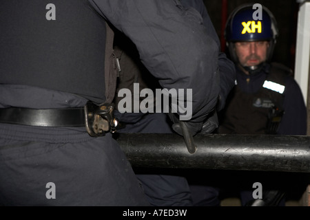 Police break down a front door during a raid on suspected drugs dealers ...