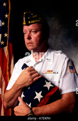 sad American soldier holding flag of United States while crying during ...