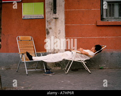Sleeping Chinese on a street of Shanghai. People take a nap anywhere ...