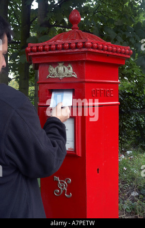 Man posting a letter in a Victorian post box Stock Photo - Alamy