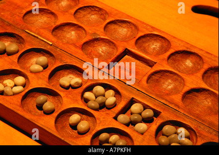 A traditional African wooden game with seeds, the awale. Concept around ...