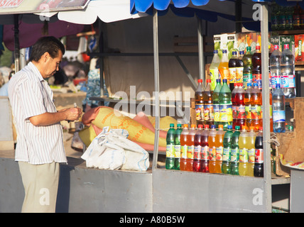 Men standing next to shop stall open to street Stock Photo - Alamy