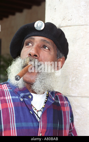 Cuban man with unusual beard in colourful dress smokes cigar in old ...