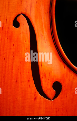 Vertical close up of violin f-hole, fine tuners, strings and bridge in ...