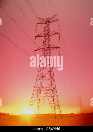 Tall electricity pylons and cables in an urban environment by the side ...
