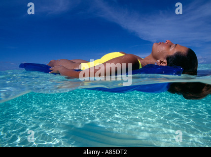 Cayman Islands Grand Cayman woman in thong sitting on beach at ...