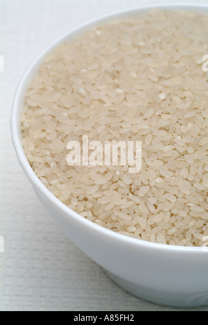 White rice in a bowl on a blue background, ser Stock Photo - Alamy