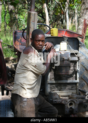 Environmental portrait of poor African black man with tractor wheel in ...