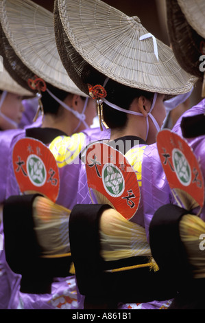 Women in kimono and torioigasa straw hats dance together in the streets ...