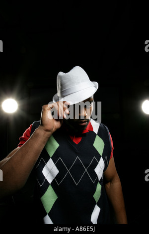 Portrait of a young man tipping his hat at a bar counter and smiling ...