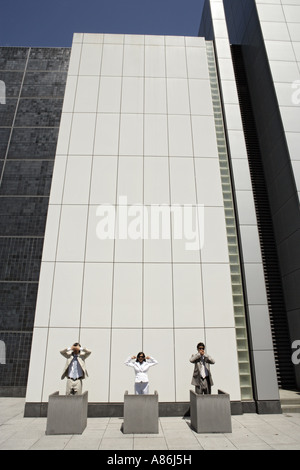Three businesspeople standing outdoors by building smiling Stock Photo ...