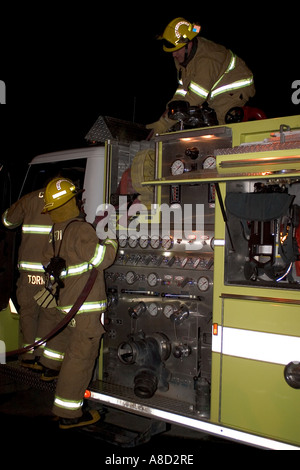 Fireman loading hose back on fire truck at a night fire drill Stock ...