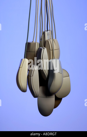 Several computer mice hang on a pastel pink background. The concept of ...