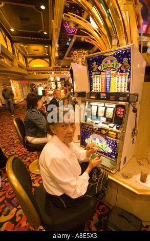 Las Vegas Casino - An Elderly lady plays slot machine Stock Photo - Alamy