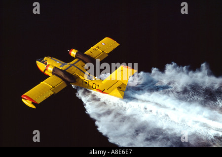 A firefighting aircraft fills its' water tanks during a wildfire in ...