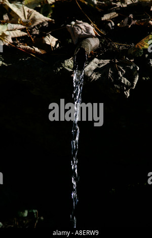 Water flowing out of an overflow pipe set in a concrete wall Stock ...