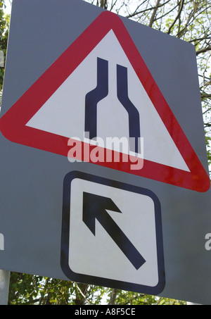 Road narrowing traffic sign, cars and houses in Menton reflect in a ...