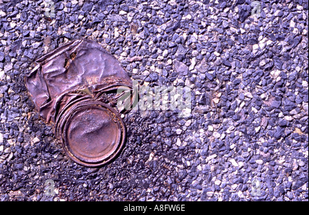 A flattened rusty can of beans on a bitumen road Stock Photo - Alamy