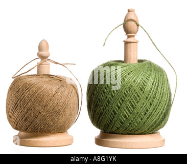 Green garden string on a spool and scissors with orange handles hung on ...
