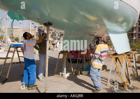 Man painting a ships hull in a ship repair yard, Grimsby, Humberside ...