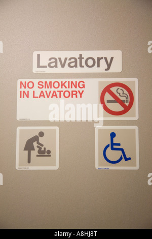Airplane toilet door with No Smoking warning signs beside an ashtray ...