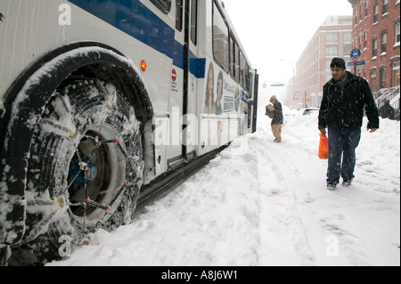 A New York City bus with chains on its tires for traction in the snow ...
