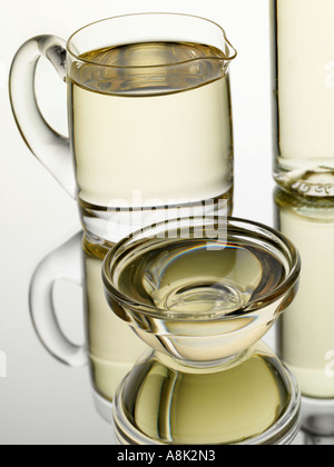 Almond essential oil in glass bottle with spoon, raw almond nuts ...