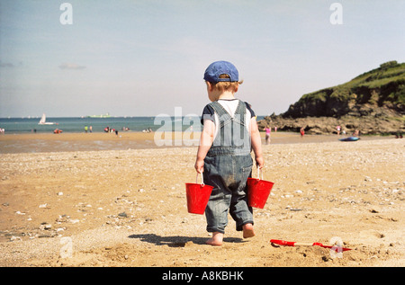 Boy carrying two buckets of water in Malvani slum ; Malad ; Bombay ...