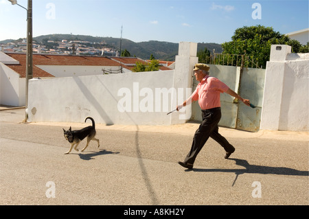 An angry man chases a stray dog at Aljezur Algarve Portugal Stock Photo ...