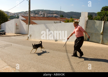 An angry man chases a stray dog at Aljezur Algarve Portugal Stock Photo ...