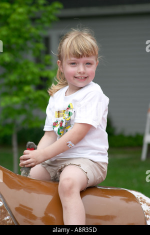 A little girl riding a mechanical bull at the East Tennessee Strawberry ...