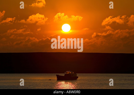 Pleasure boat in the sea in the late evening at sunset Stock Photo - Alamy